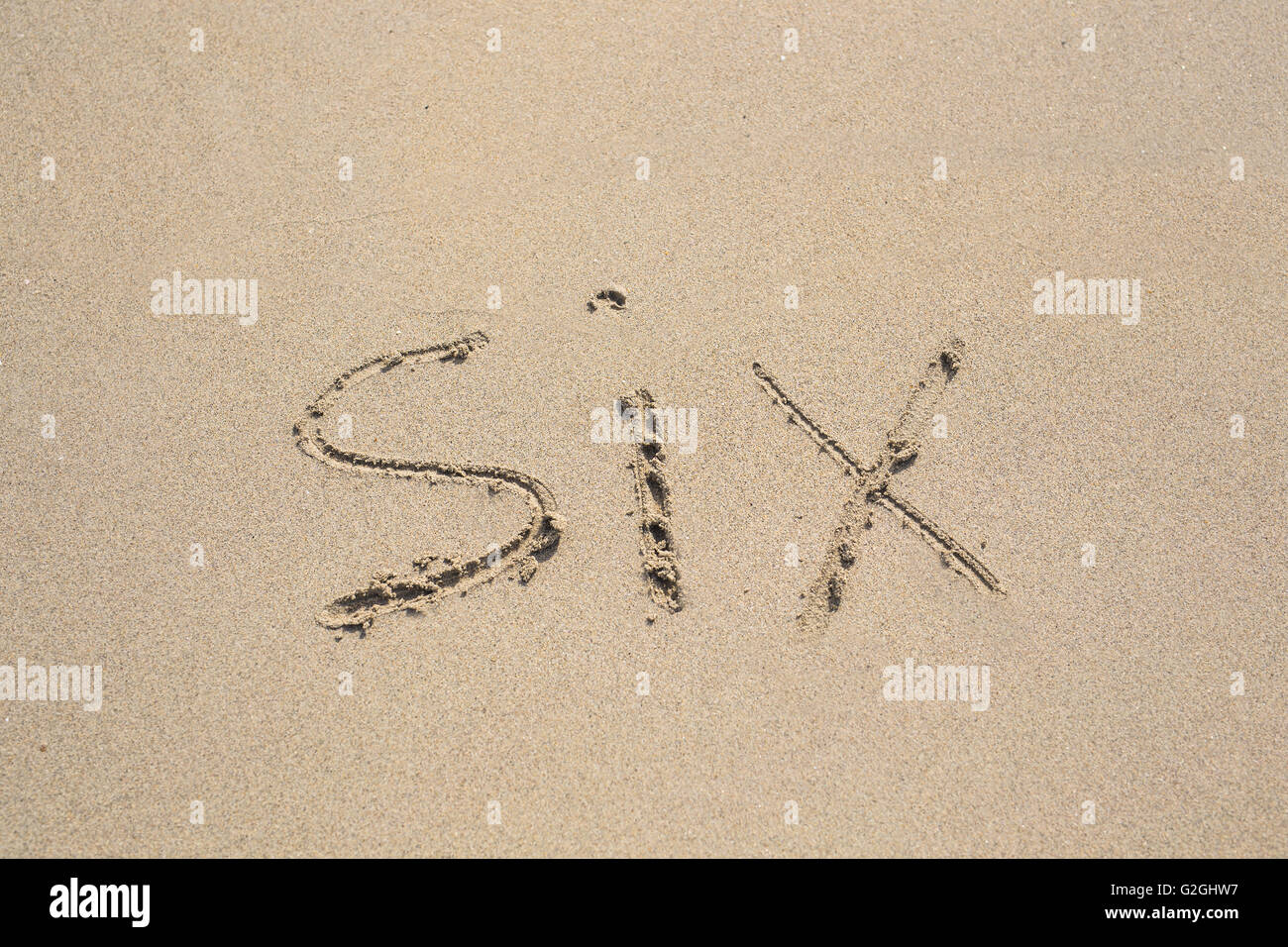 Six number written on sand. Summer beach background Stock Photo - Alamy
