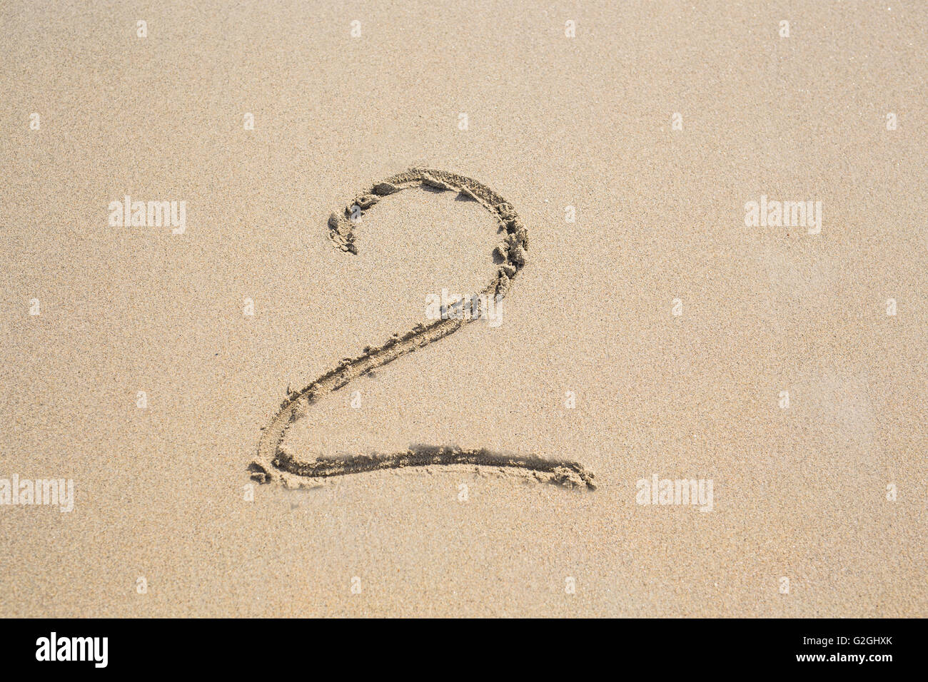 Two written in the sand at a beach Stock Photo - Alamy