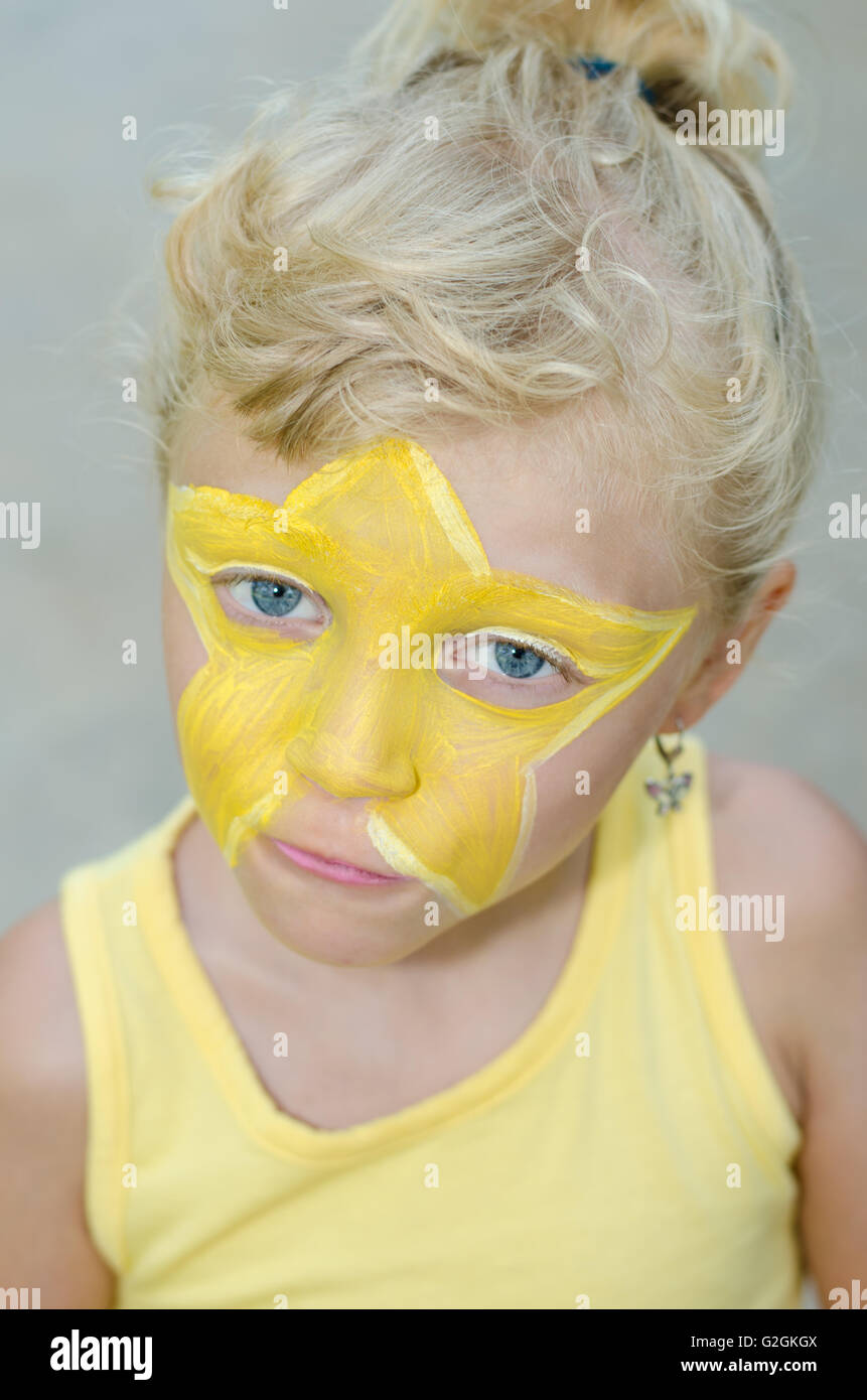beautiful blond girl with yellow star face painting Stock Photo - Alamy