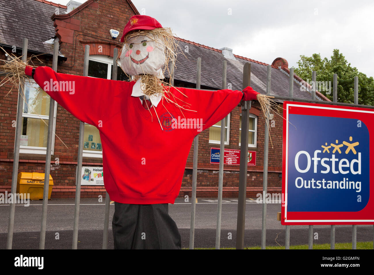 Straw pupil wearing red shirt and cap. Schoolboy scarecrow outside ...