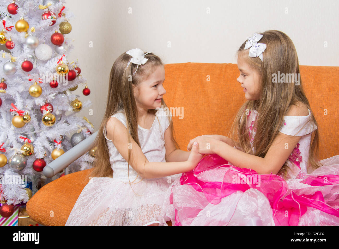 Two girls in beautiful dresses waiting Gift joined hands Stock Photo ...