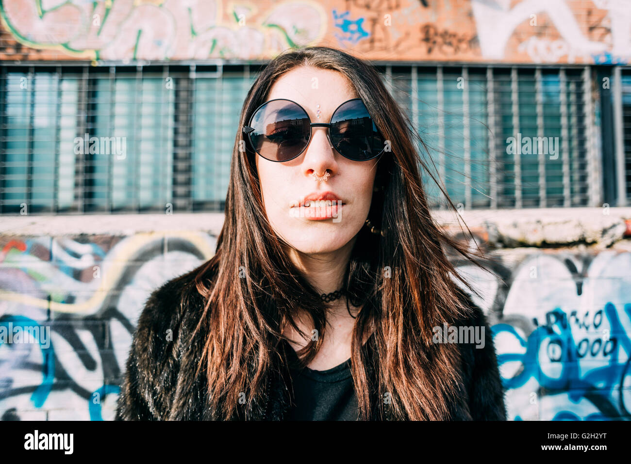 Portrait of young beautiful brown hair indie woman with septum piercing ...