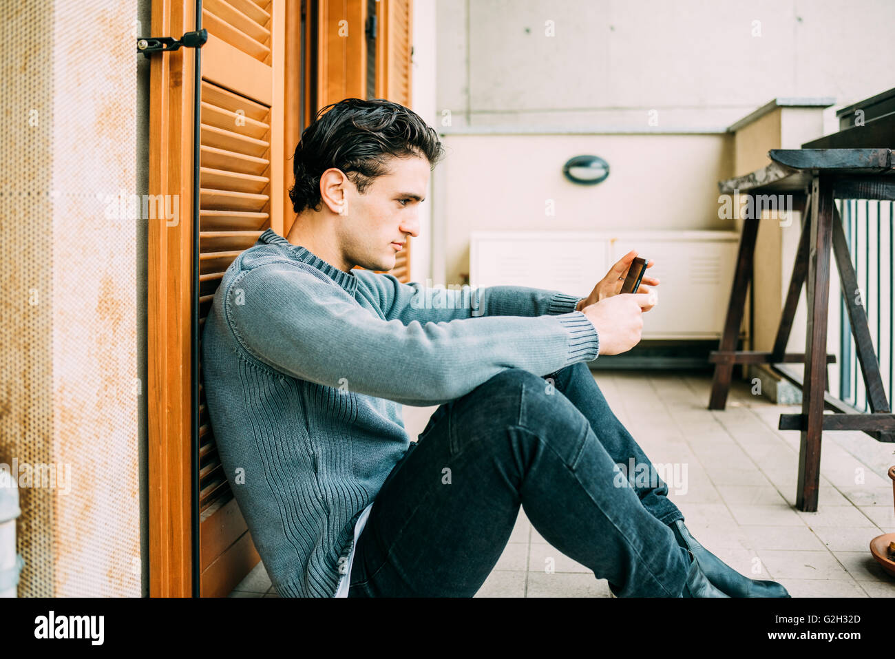 Man tapping phone on balcony hi-res stock photography and images - Alamy