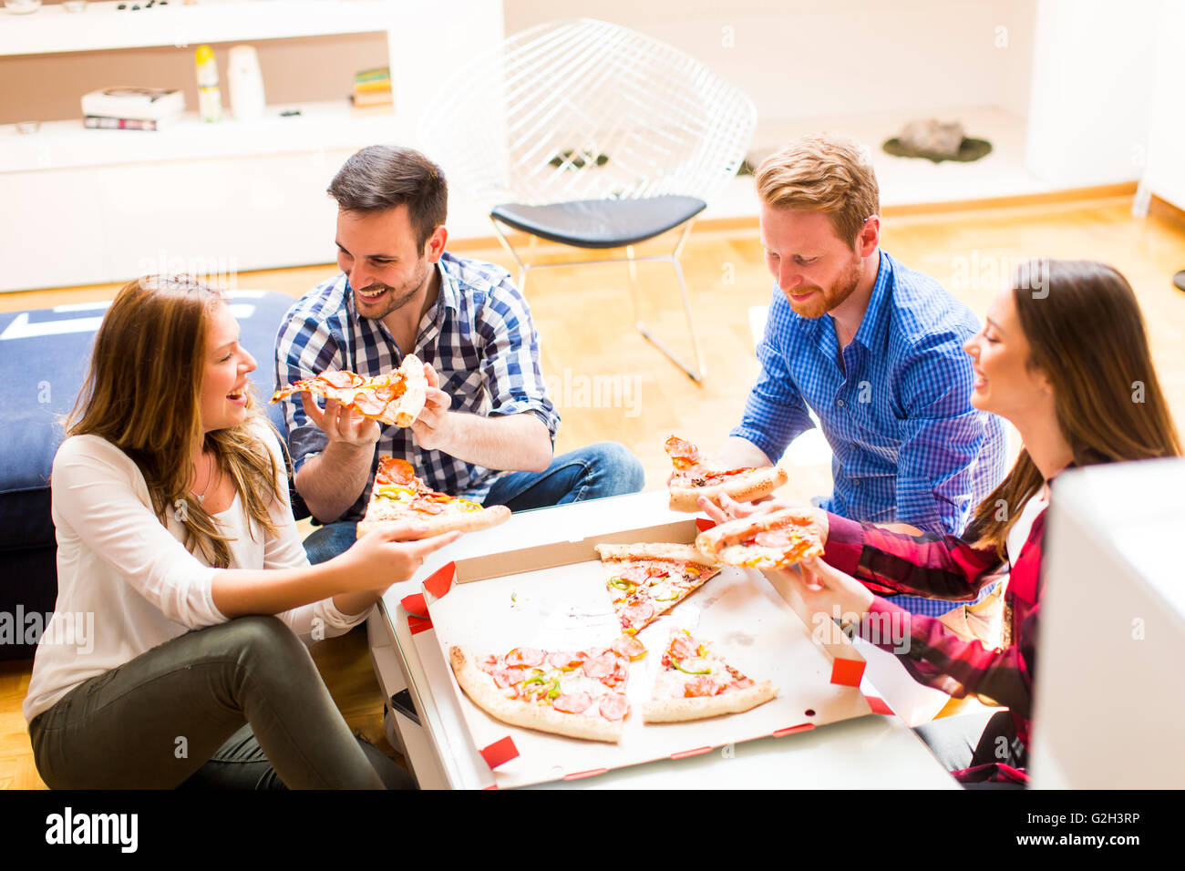 Group of friends eating pizza together at home Stock Photo - Alamy