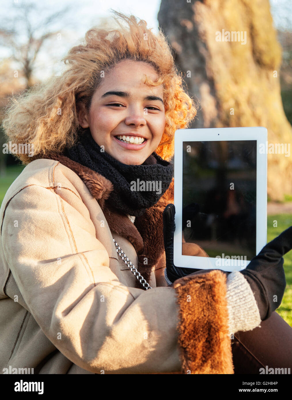young cute blond african american girl student holding tablet and ...