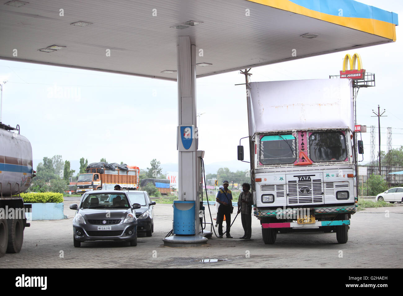 Cars and trucks filling petrol and diesel at a gas station in india ...