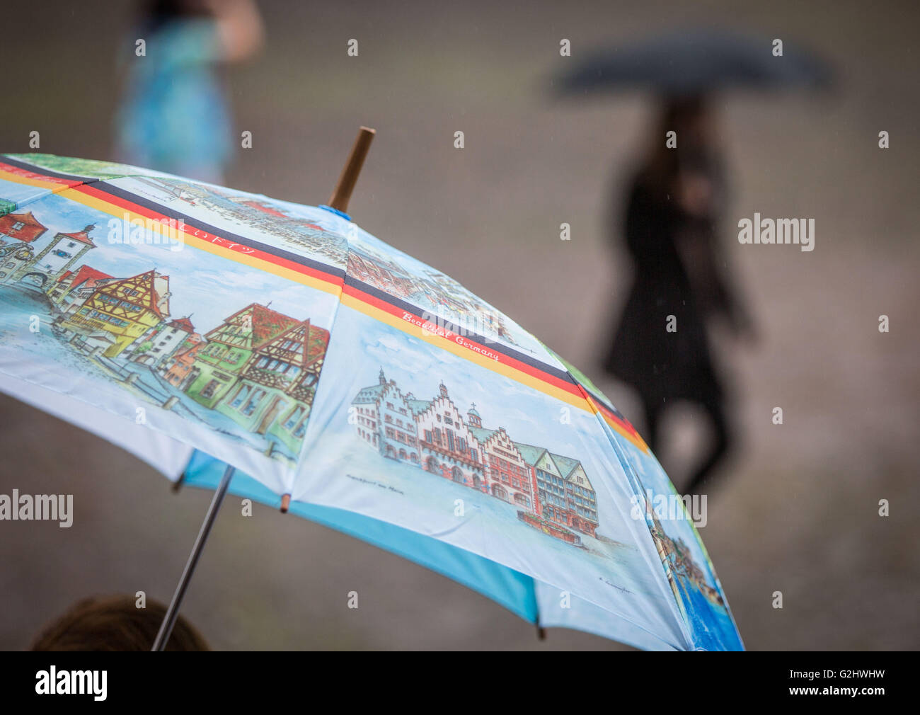 A tourist holds an umbrella with pictures of German half-timpered ...