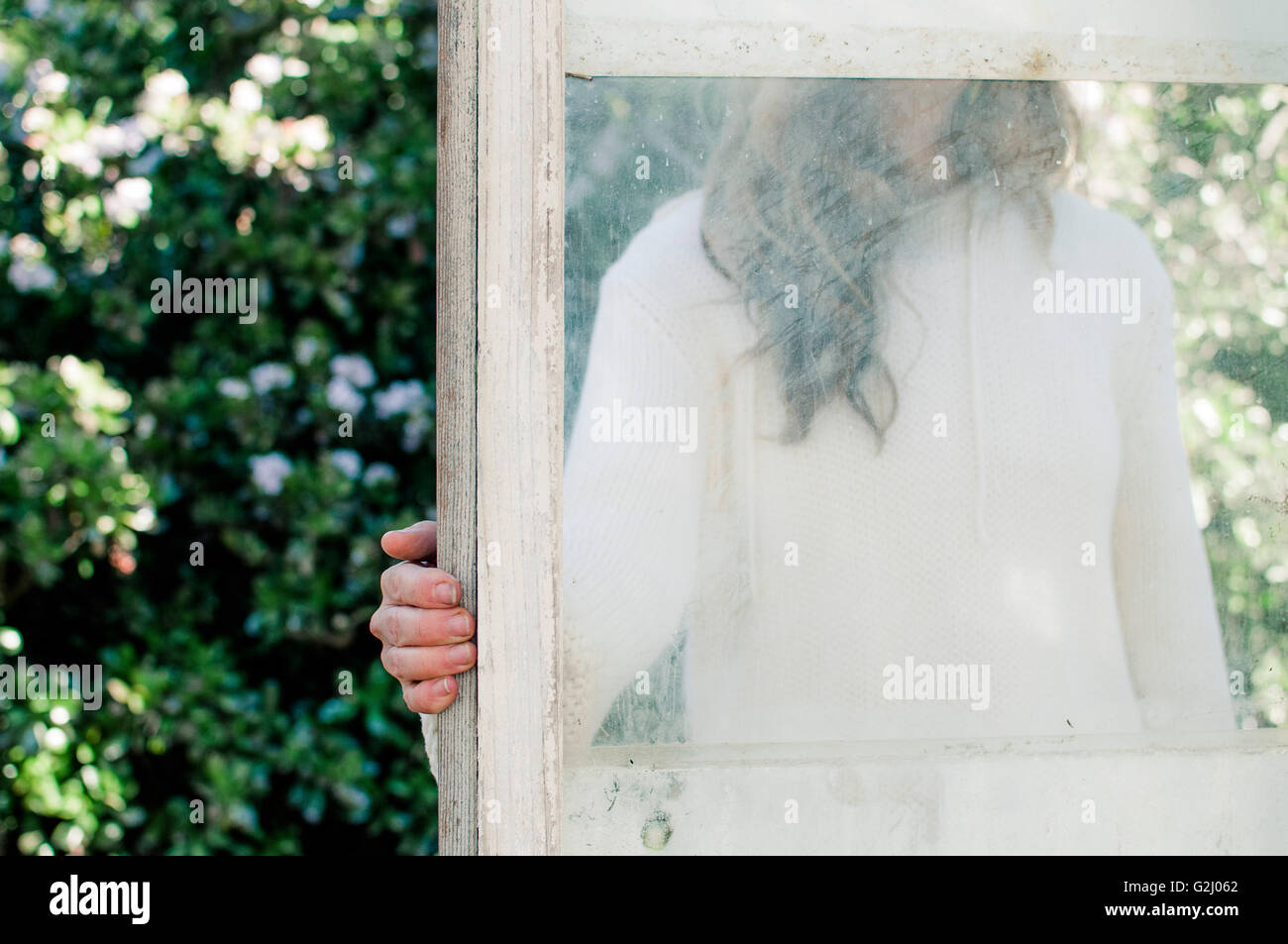 Portrait of Woman Standing Behind Glass and Wood Door Stock Photo - Alamy
