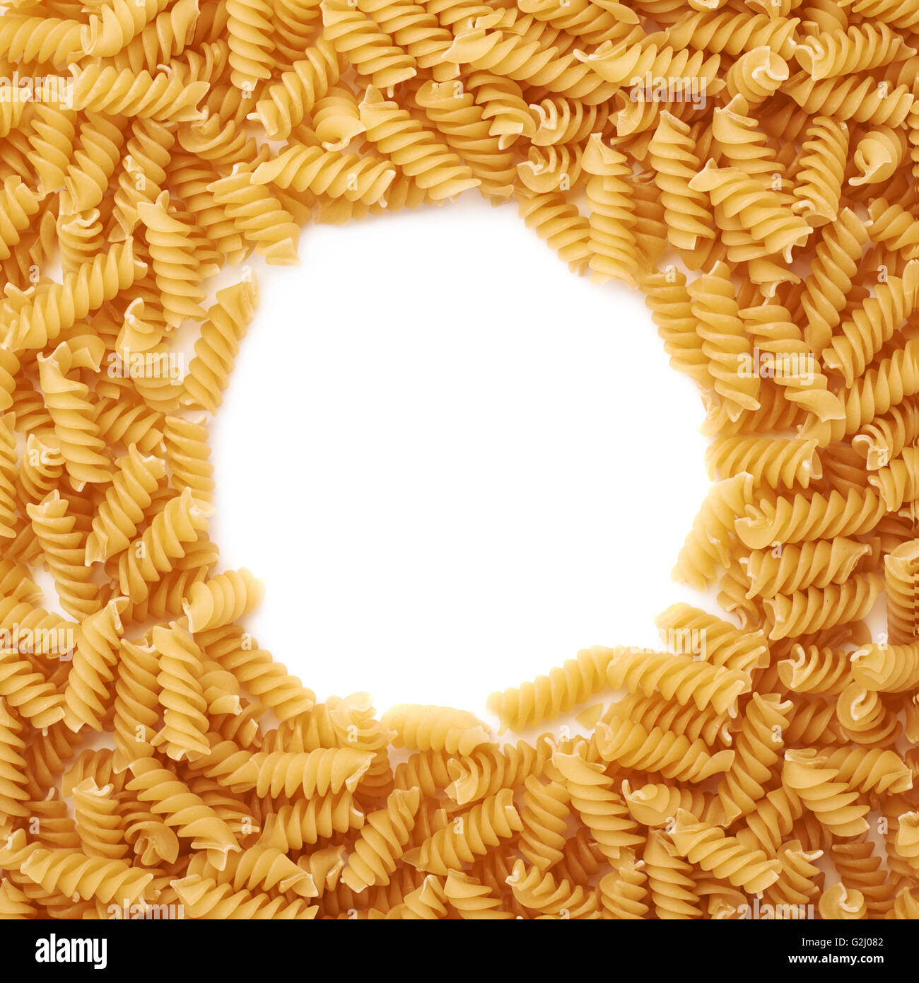 Round frame made of dry rotini pasta over isolated white background ...