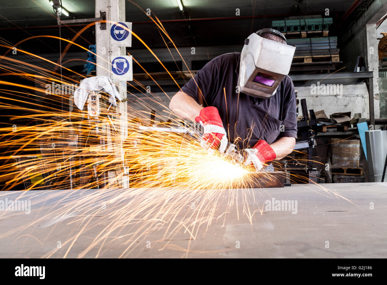 Worker Grinding metal in a workshop with sparks flying Stock Photo - Alamy