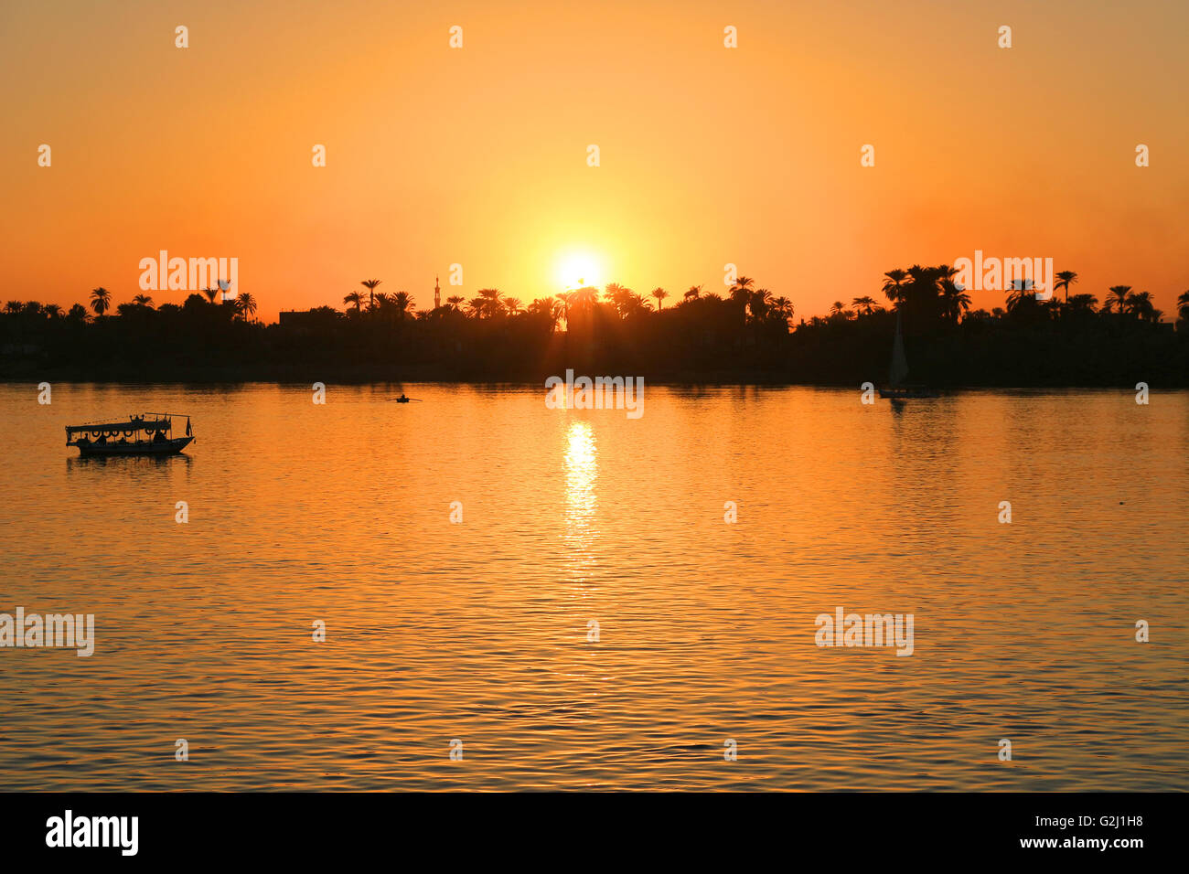 Golden sunset along the Nile River in Egypt with boat making it's ...