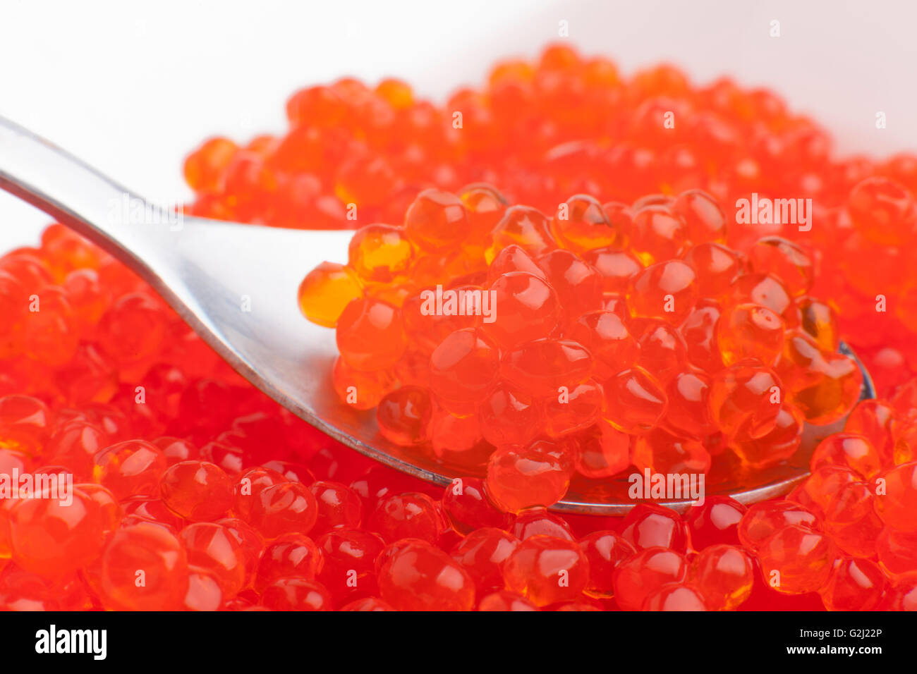 Read caviar with silver color spoon on white background Stock Photo - Alamy
