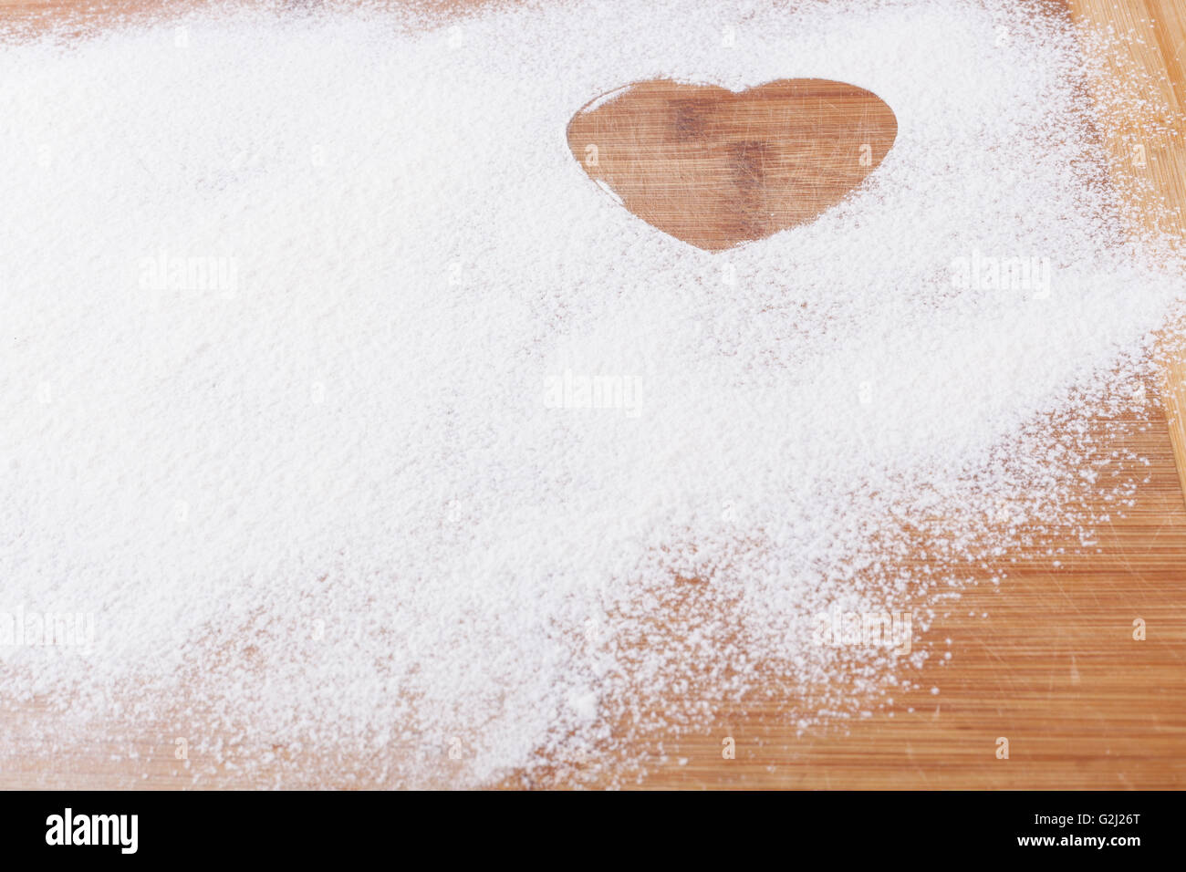 Flour shape heart in a mold on brown wood cutting board Stock Photo - Alamy