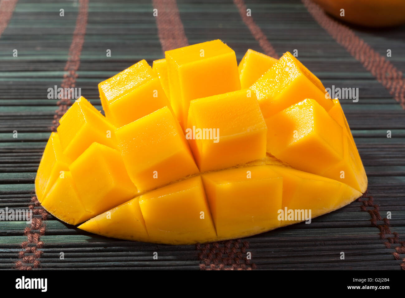 Sliced mango cubes close-up on dark table background Stock Photo - Alamy
