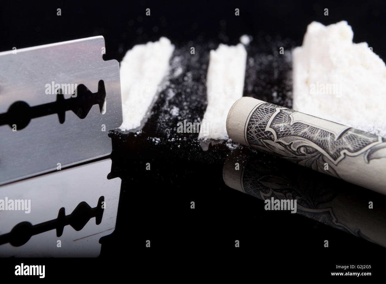Drug rows with a dollar and razor blade on dark background with ...