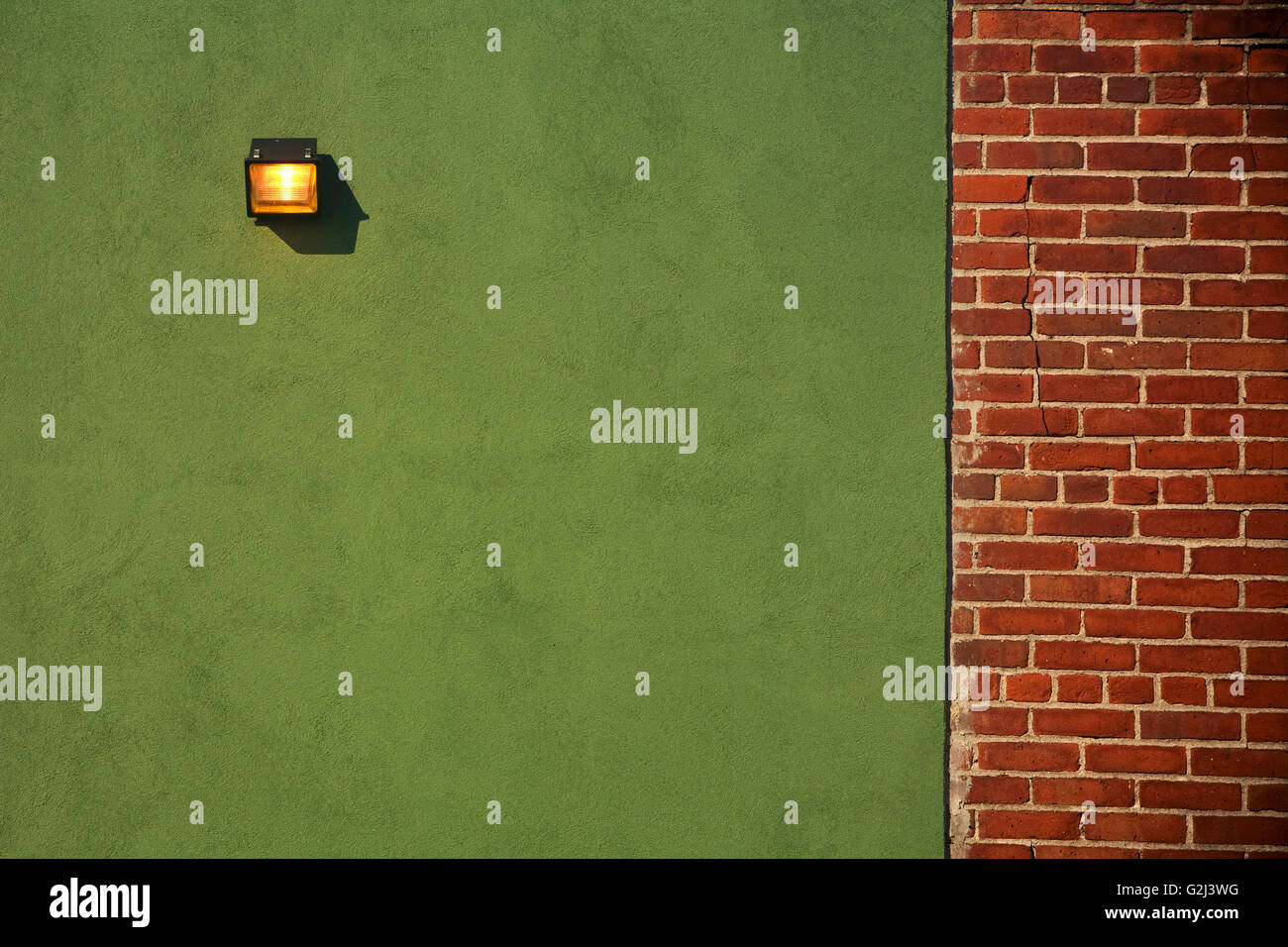 Light Fixture on Green Wall With Red Brick Wall Border Stock Photo - Alamy