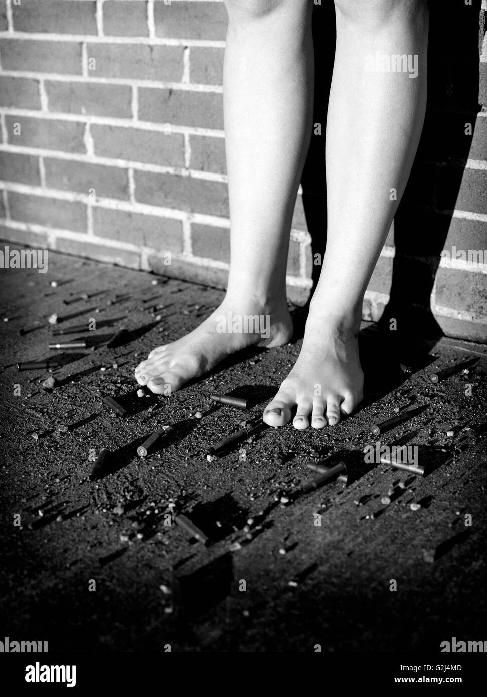 Woman's Bare Feet on Pavement Surrounded by Bullet Shell Casings Stock ...