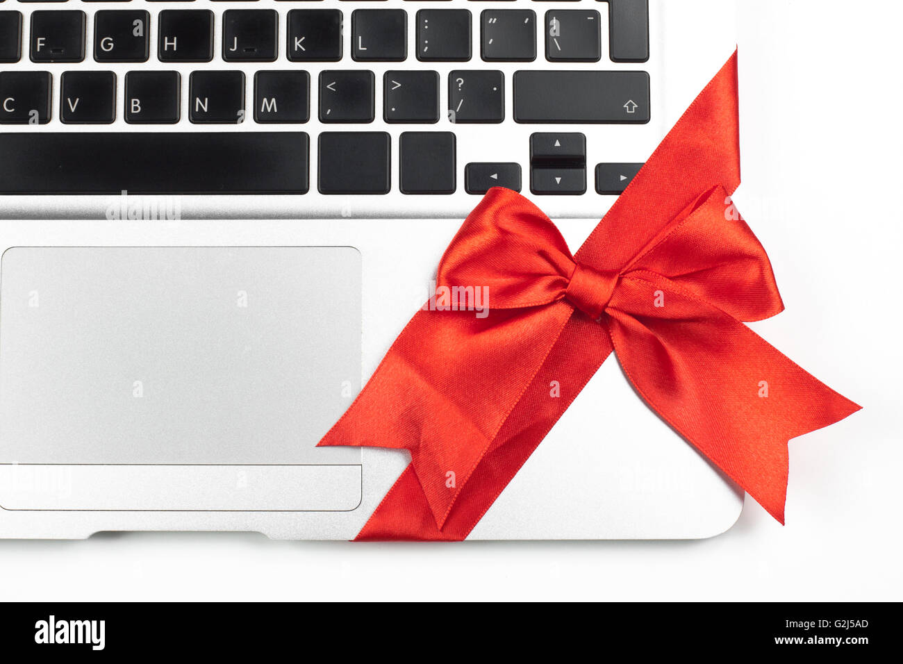 open silver laptop gift with red ribbon keyboard and trackpad closeup ...