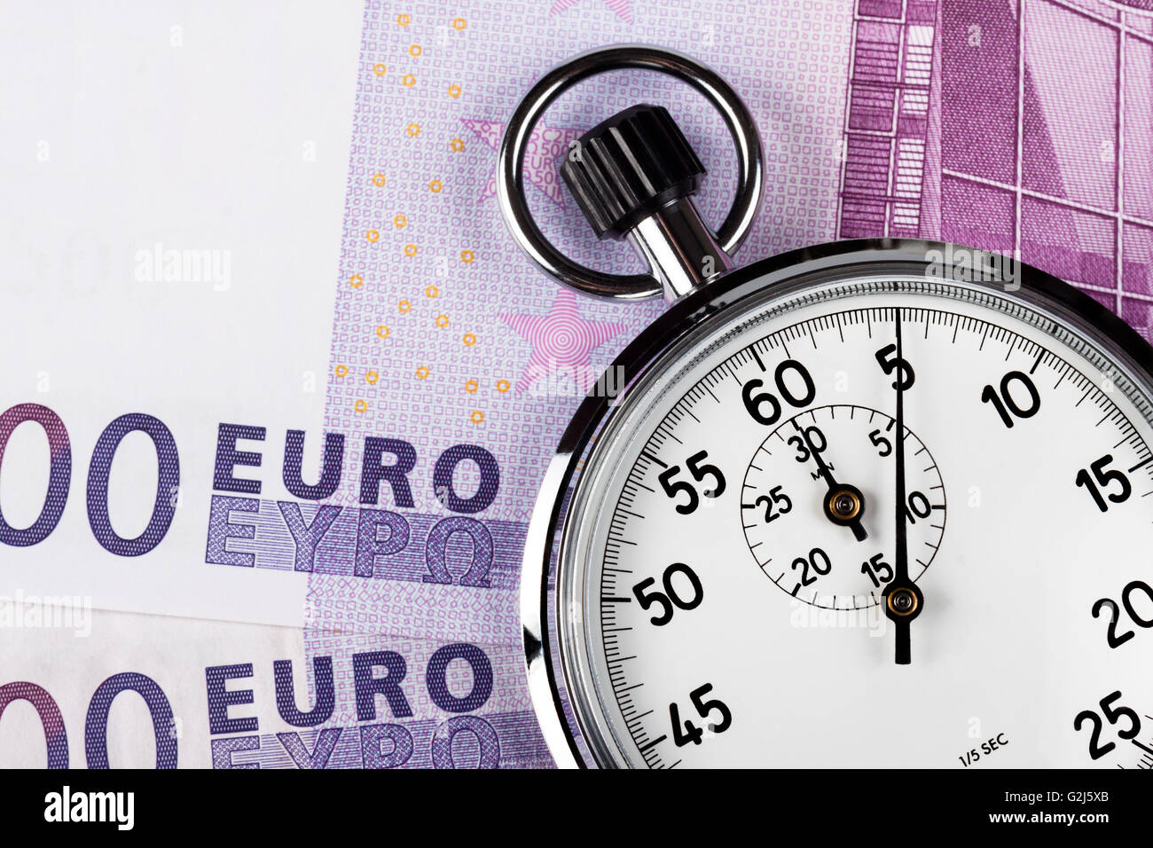 stopwatch closeup pointing at 5 seconds on a pile of 500 euro bills ...