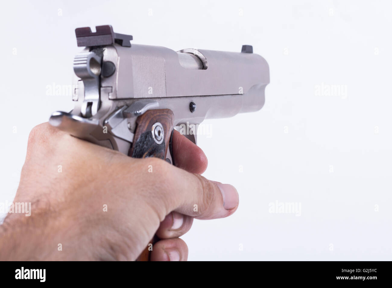 Hand holding silver colored gun isolated on white background Stock ...