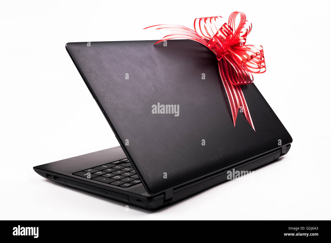 Black laptop half open with red ribbon on the back of the screen ...