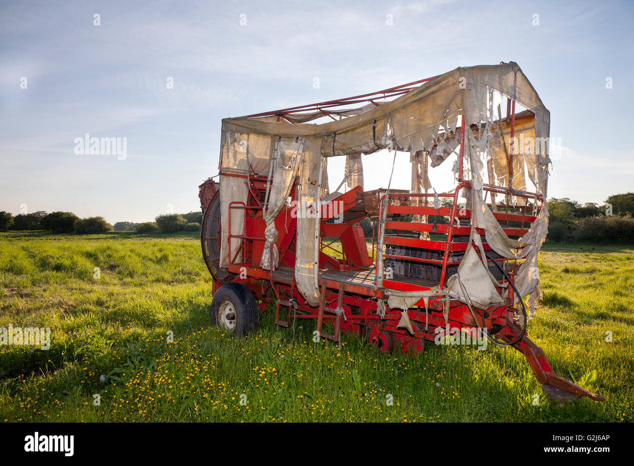 Disused GRIMME farm potato harvesting trailer illuminated in low light ...