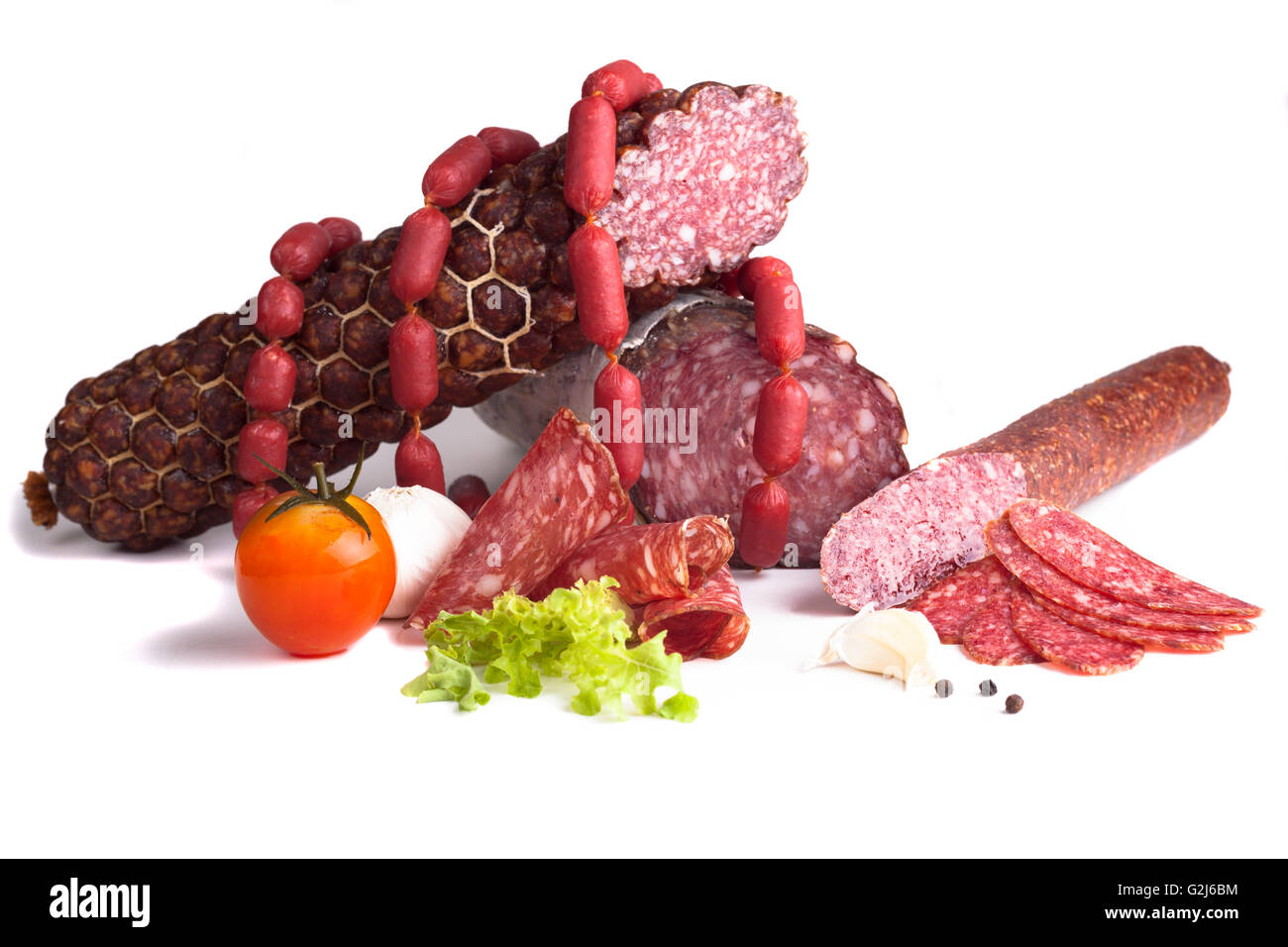 Various salami products in a with tomato isolated on white background ...