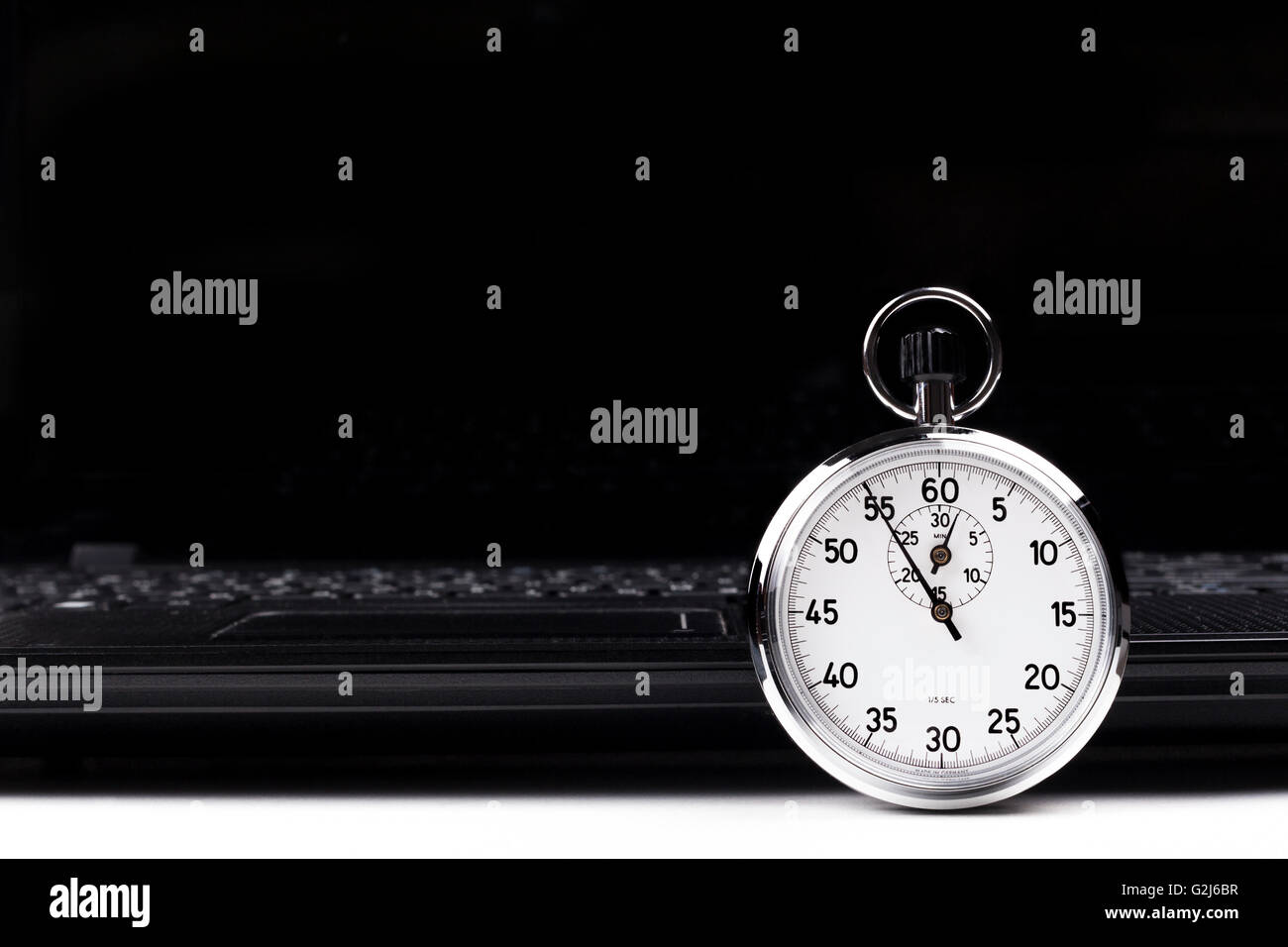 Silver stopwatch with black laptop in the background Stock Photo - Alamy