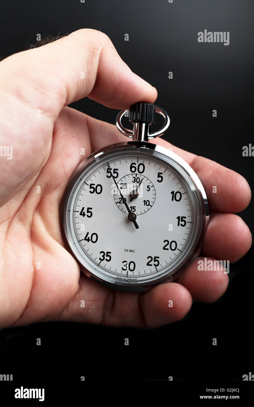 Hand holding a stopwatch on black background Stock Photo - Alamy
