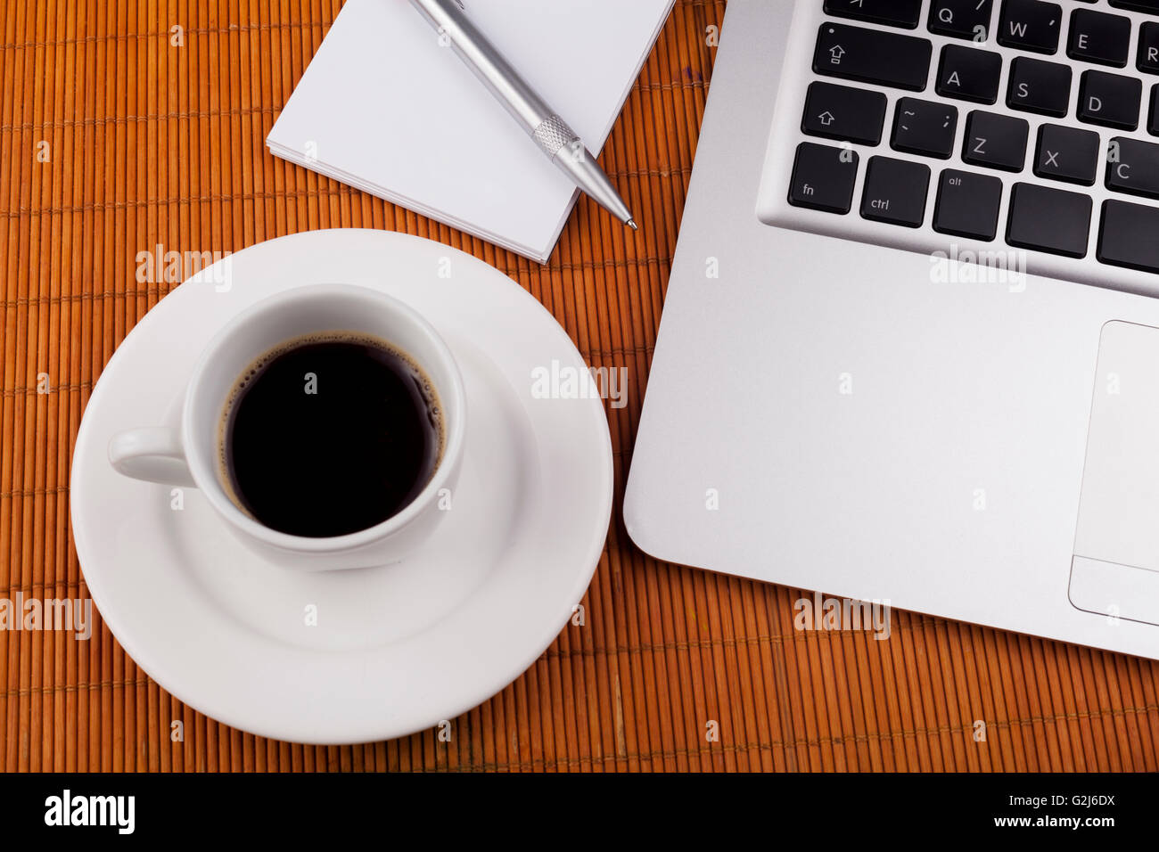 Morning coffee close-up witn laptop pen and white notebook on brown ...