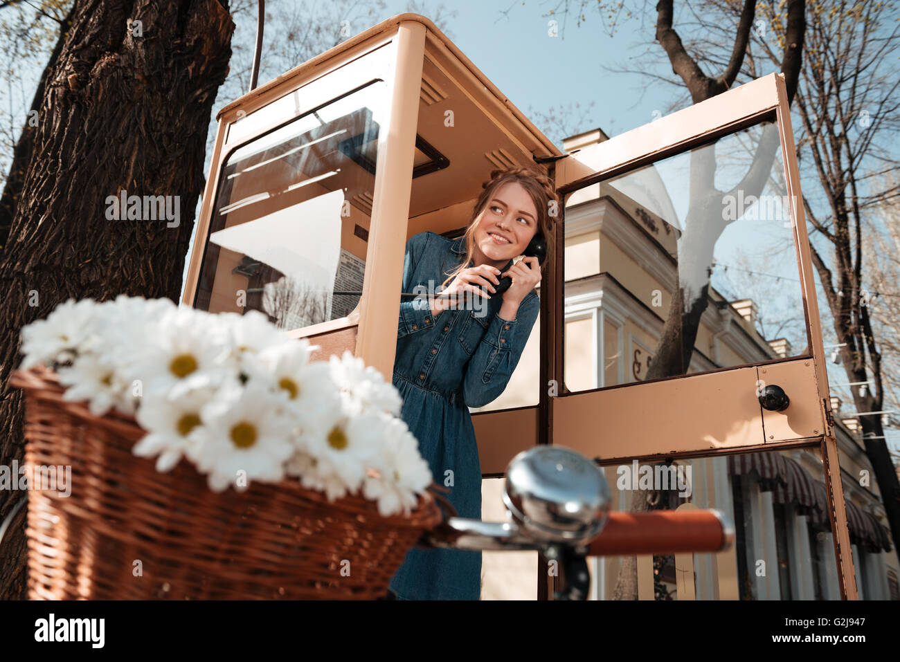 Smiling beautiful young woman using telephone box on the street Stock ...