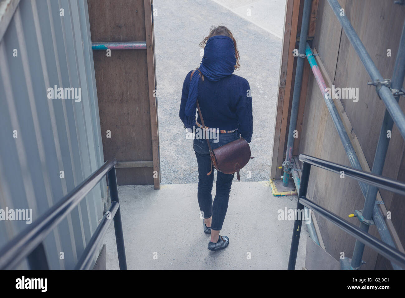 A young woman is standing at the exit of a construction site with ...