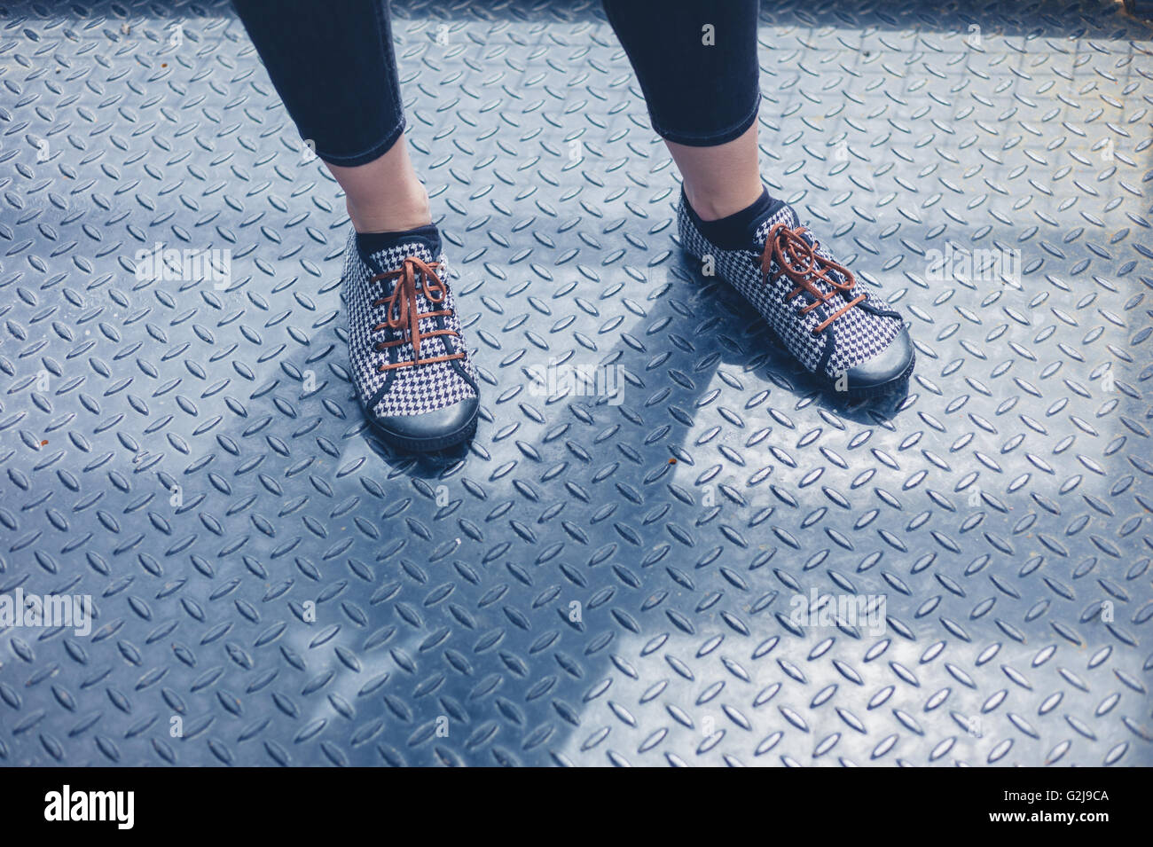 The feet of a young woman standing on a metal surface Stock Photo - Alamy