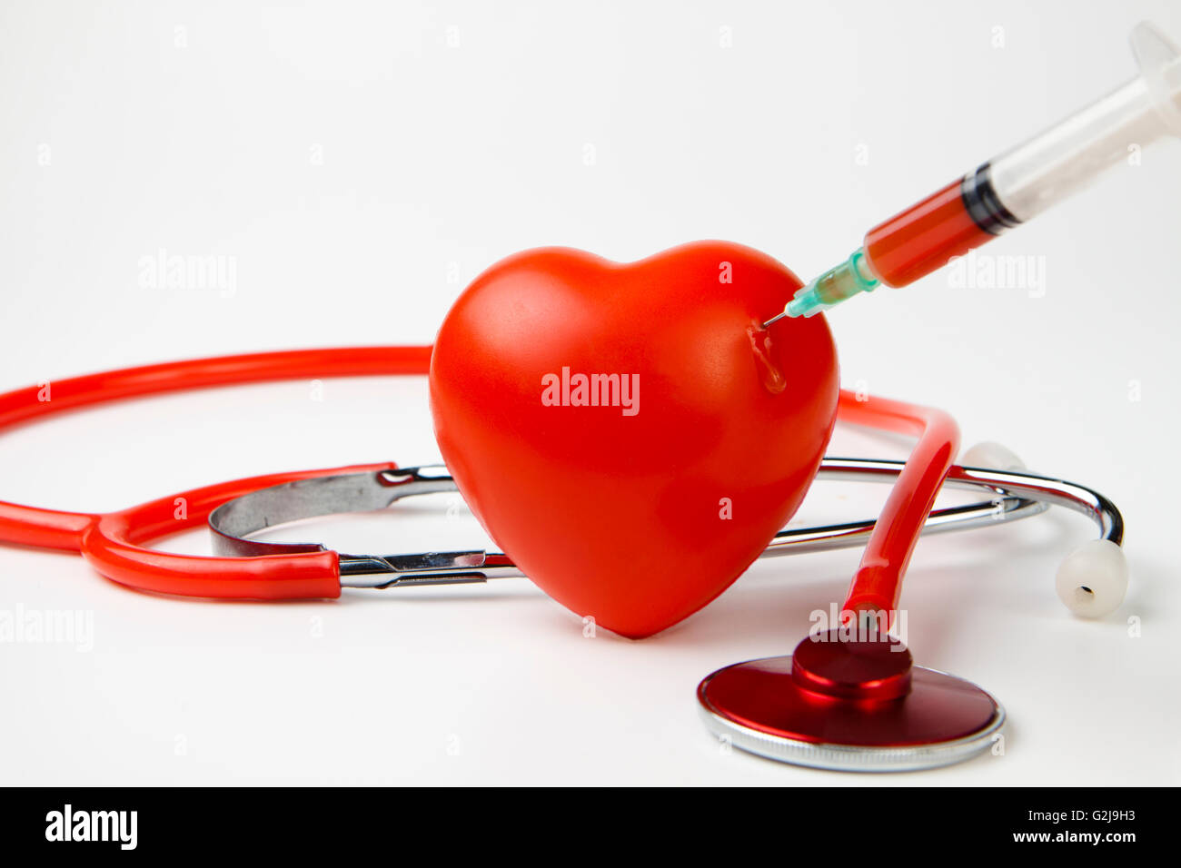 blood drop while injecting red heart with syringe on white background ...