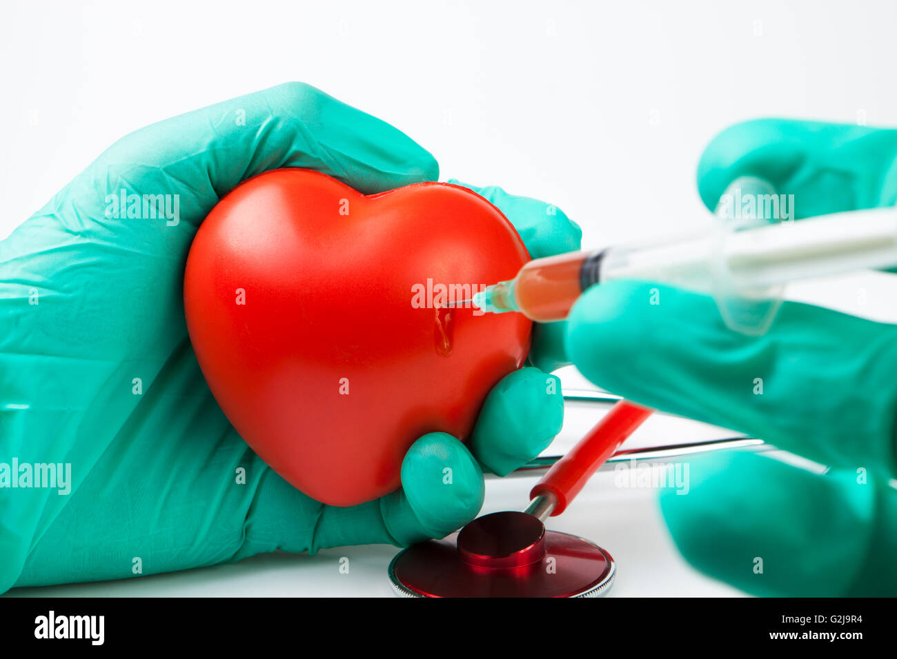 blood drop while injecting red heart with syringe with two hands green ...