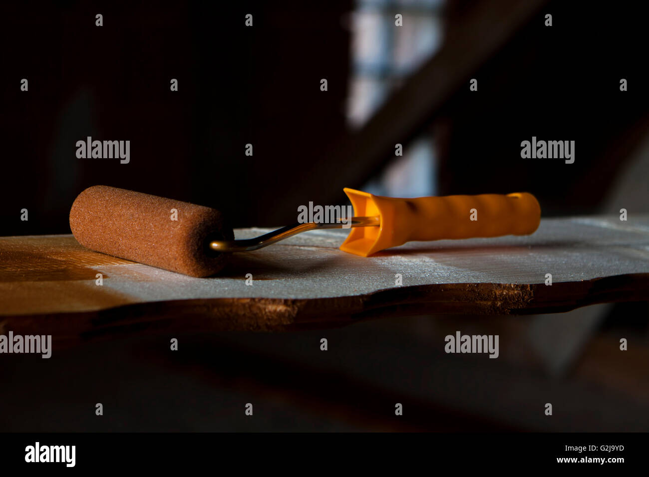 painting roller with yellow handle on a shaped wood plate Stock Photo ...