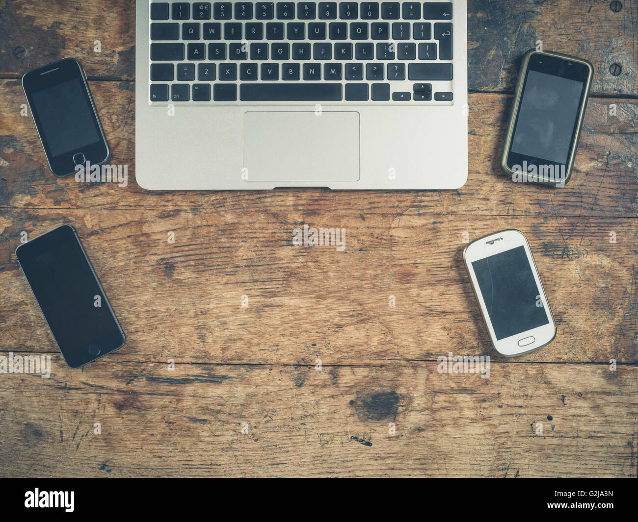 Overhead shot of a laptop computer and a selection of smart phones ...