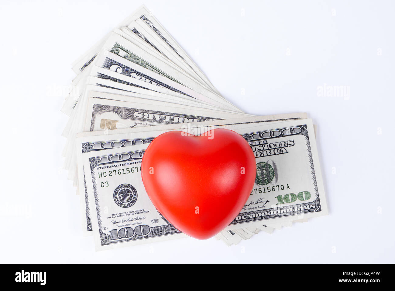 red heart on top of dollars white background Stock Photo - Alamy