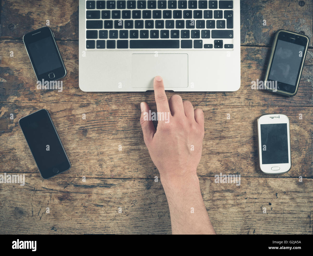 Overhead shot of a male hand using a laptop computer surrounded by a ...