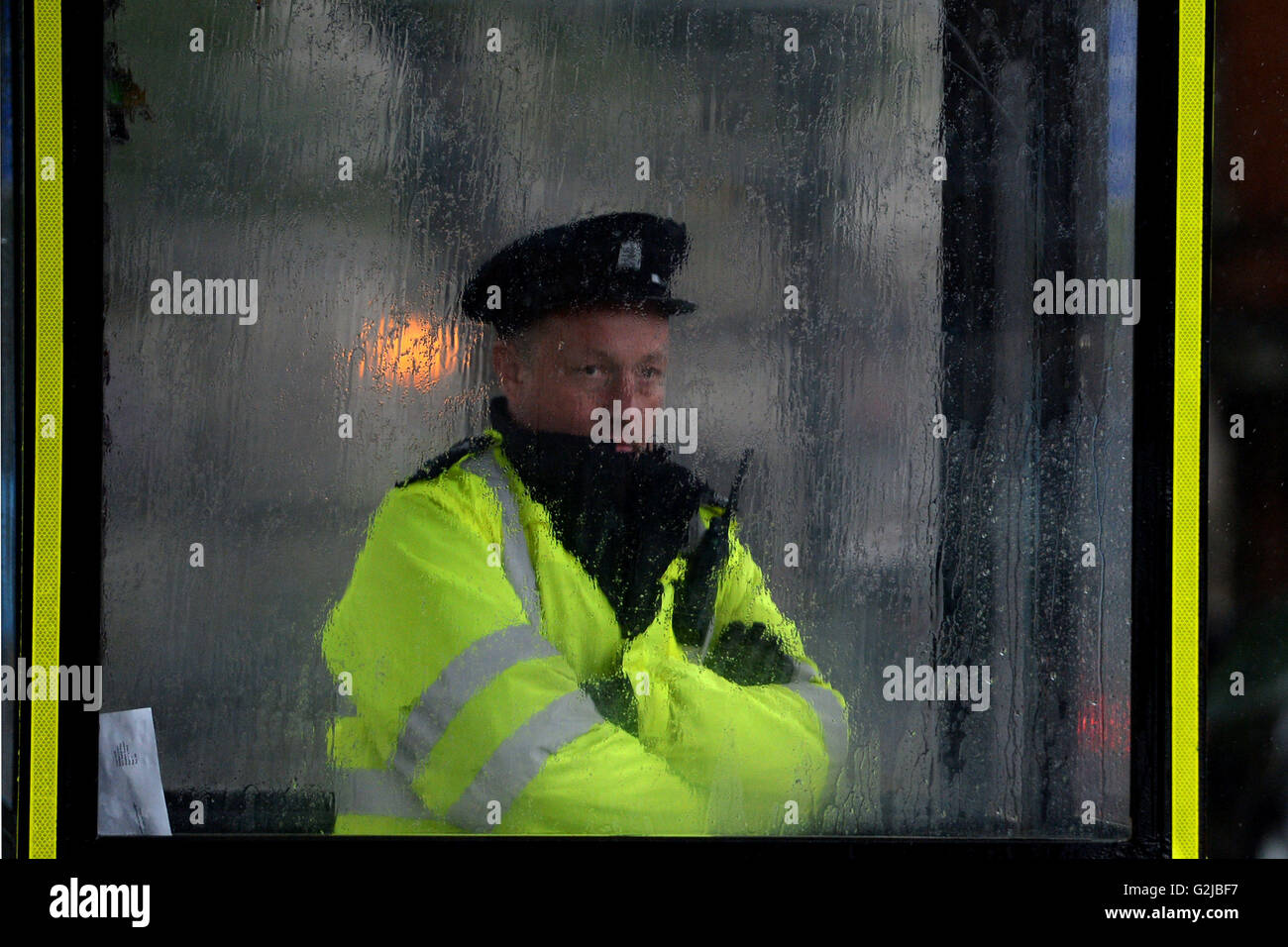 A security guard at the Houses of Parliament in central London shelters ...