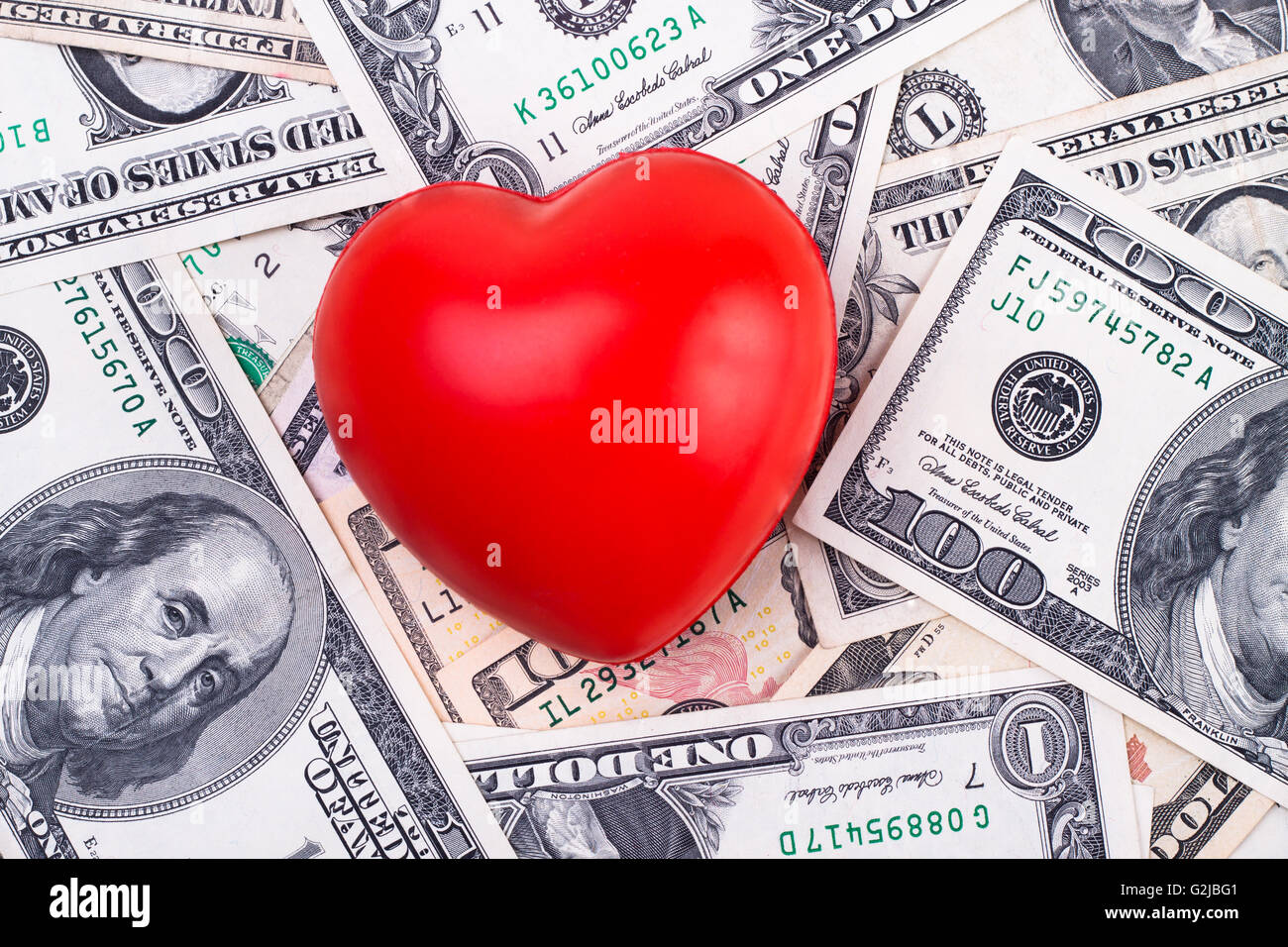 red heart on top of dollar bank notes Stock Photo - Alamy