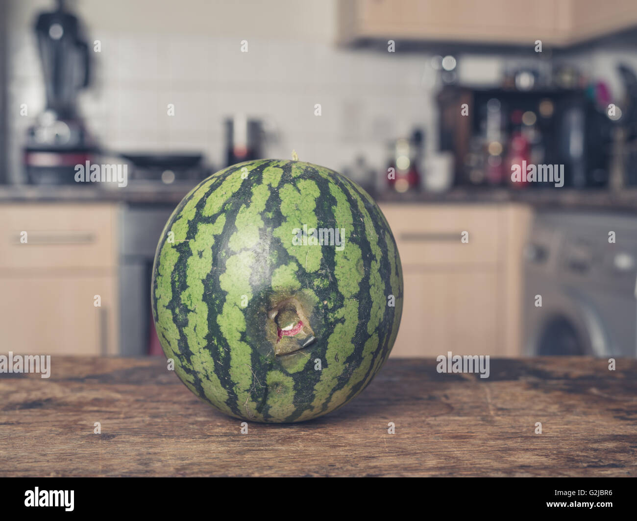 A bruised and rotten watermelon on a table in a kitchen Stock Photo - Alamy
