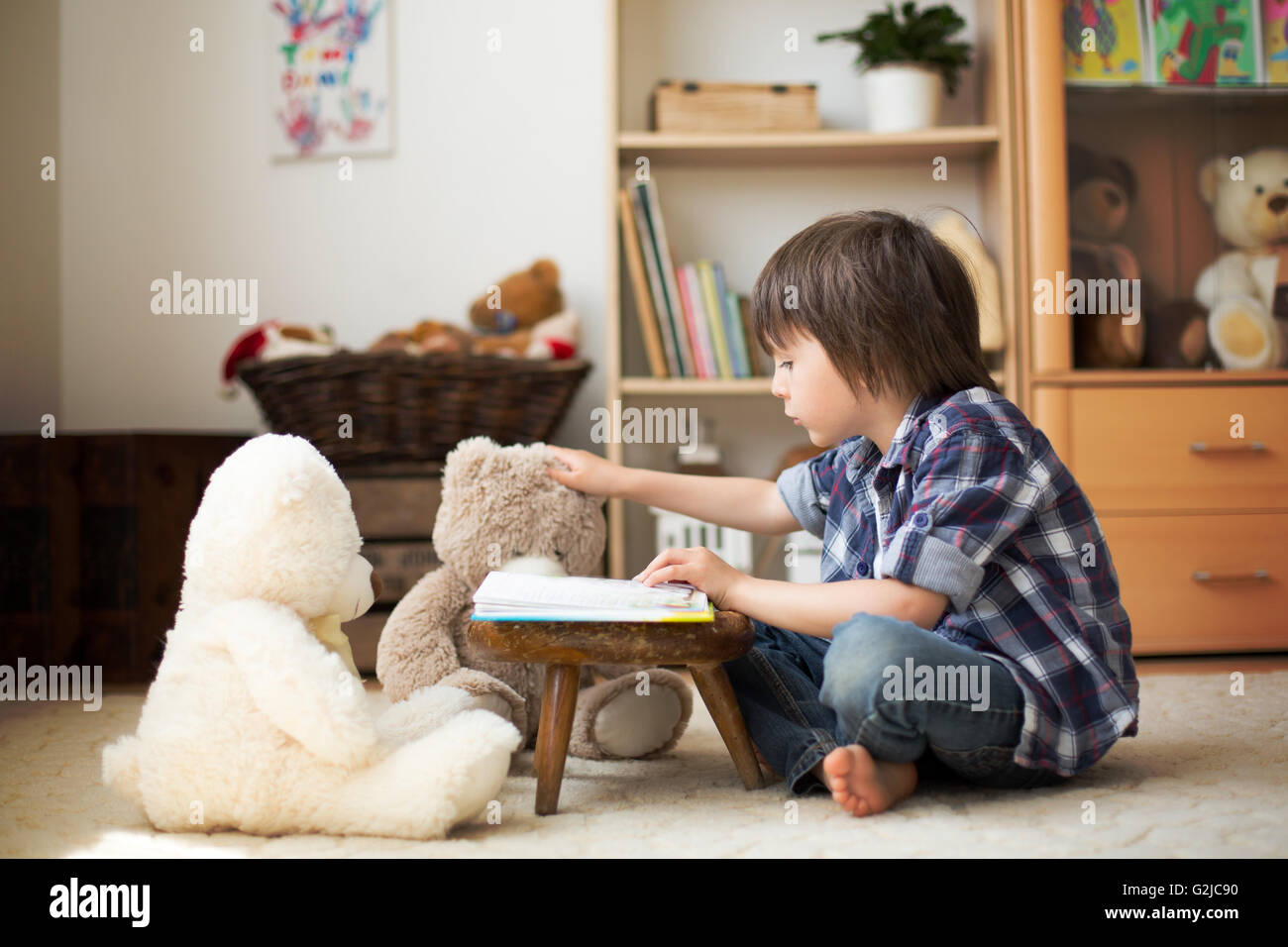 Cute little child, preschool boy, reading a book to his teddy bears at ...