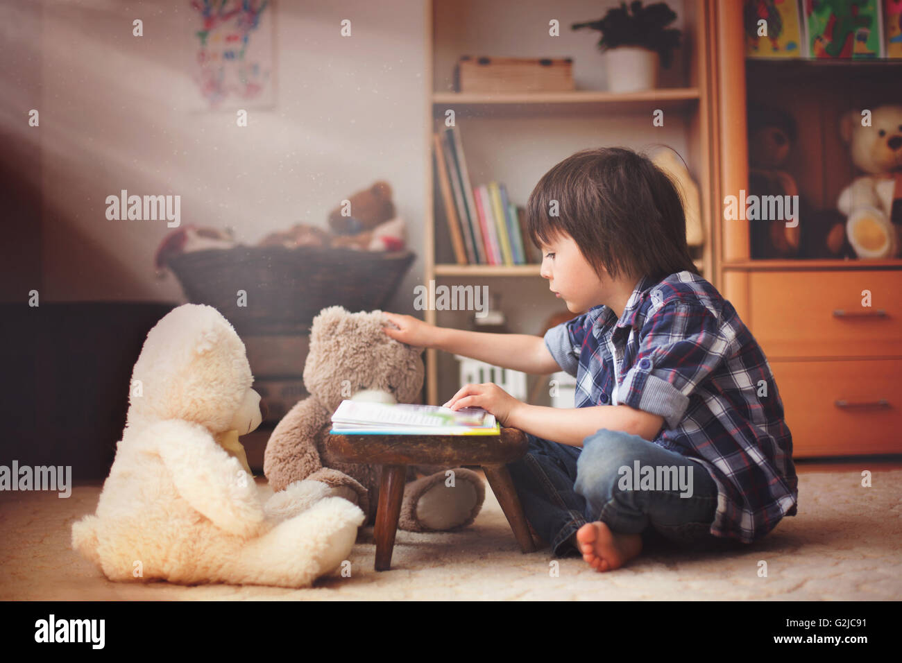 Cute little child, preschool boy, reading a book to his teddy bears at ...