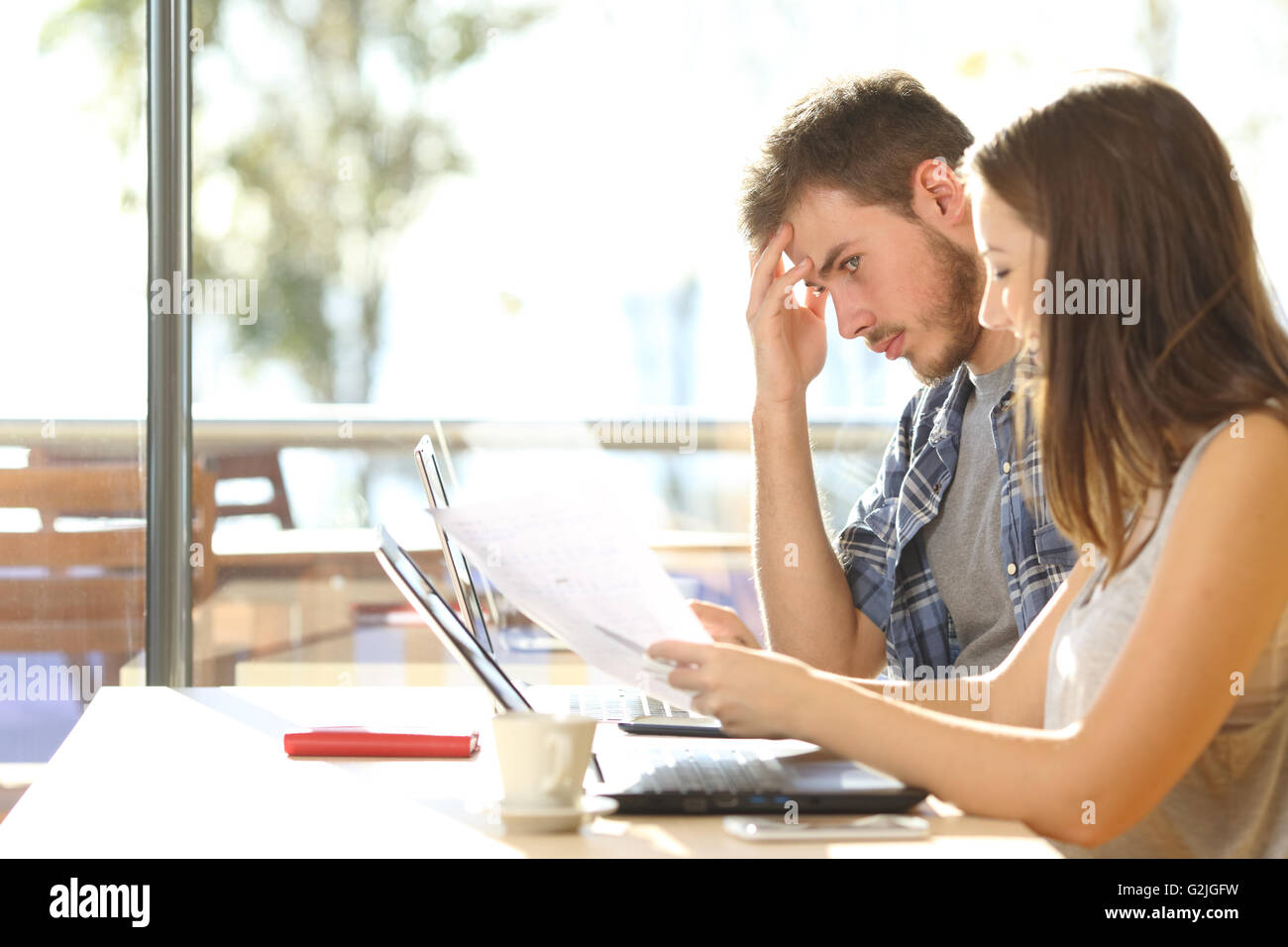 Bad student learning with difficulties and a friend teaching him in a ...