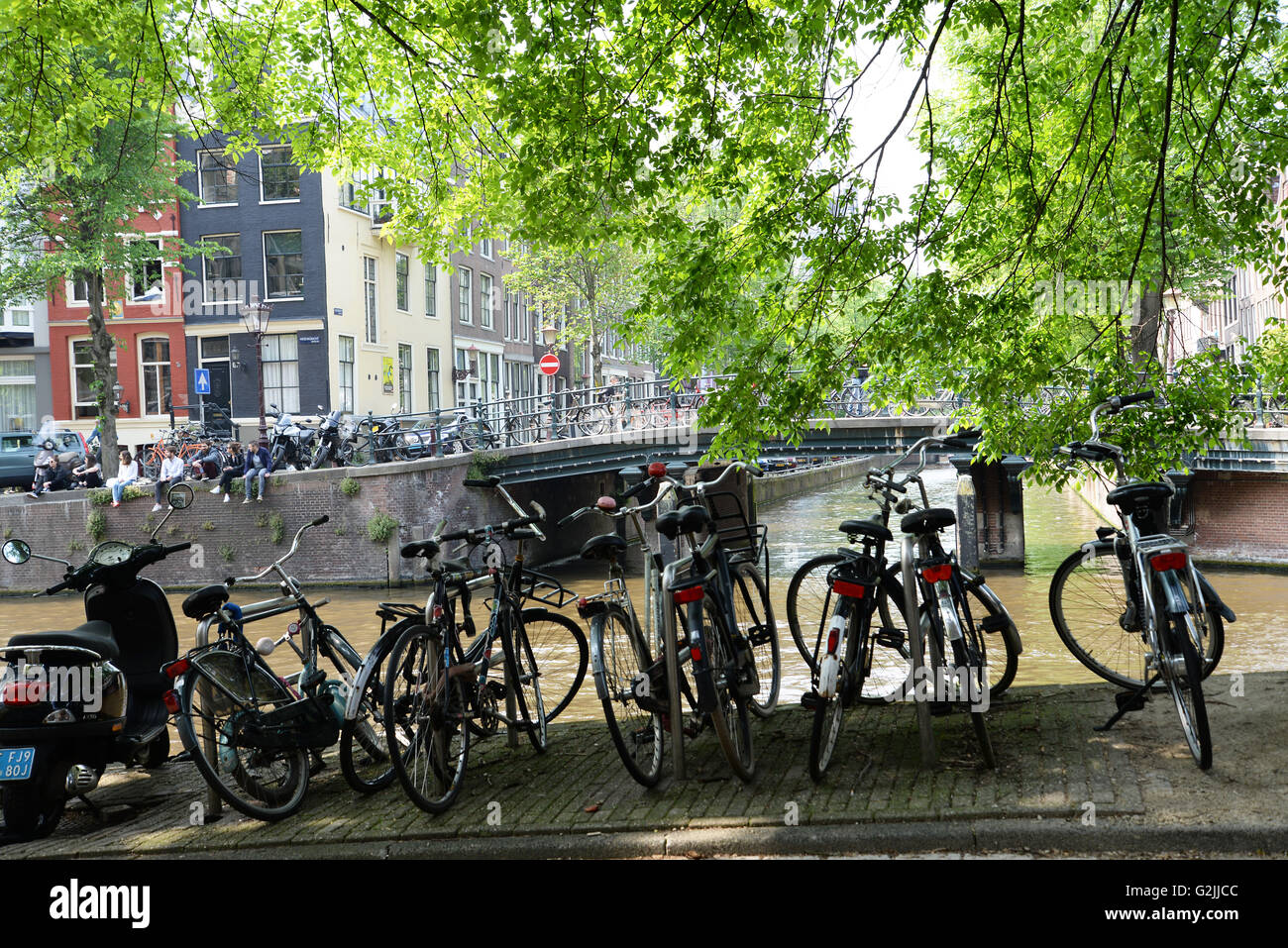 Typical Amsterdam canal roadside scene with parked and locked bicycles ...