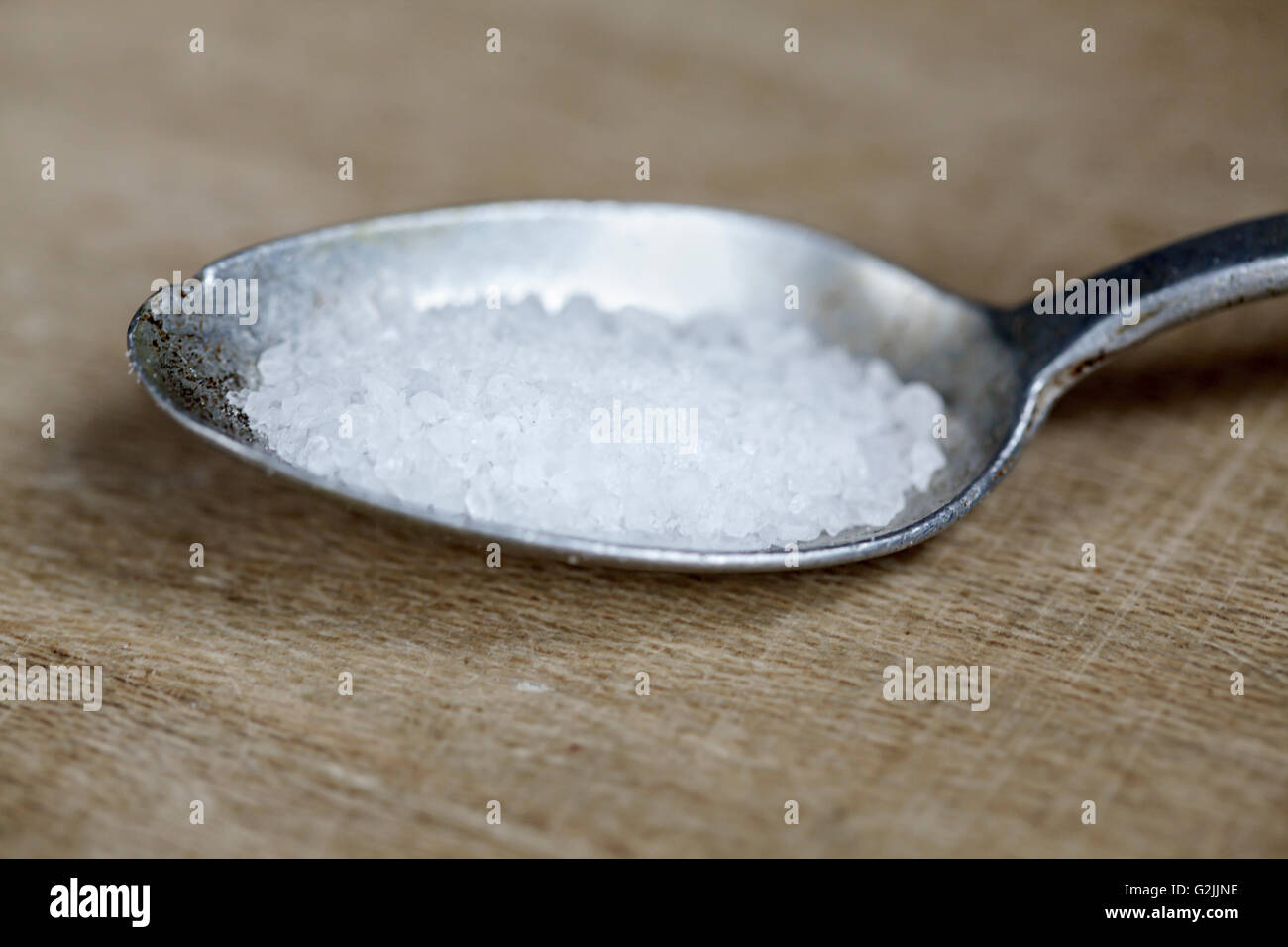 Spoon with coarse sea salt ready to be used in cooking Stock Photo - Alamy