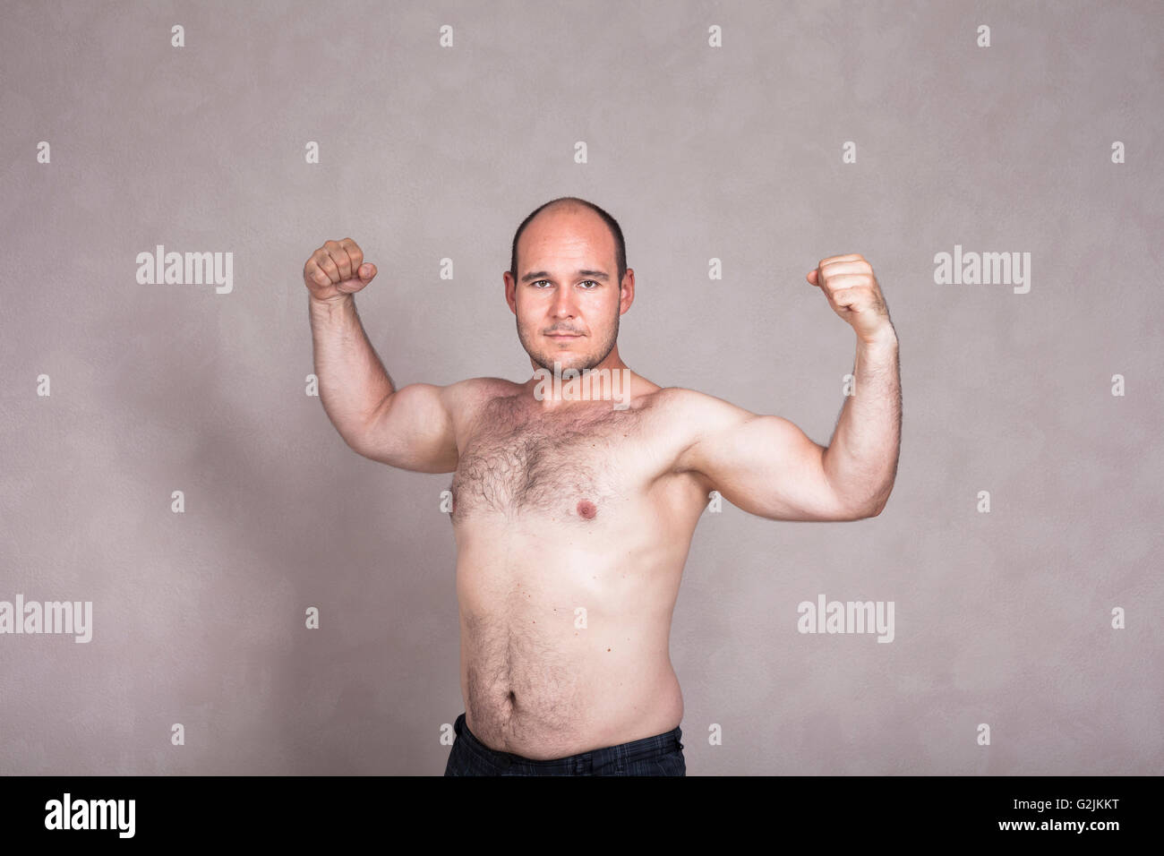 Portrait of shirtless man posing and showing his strong arms and hairy ...