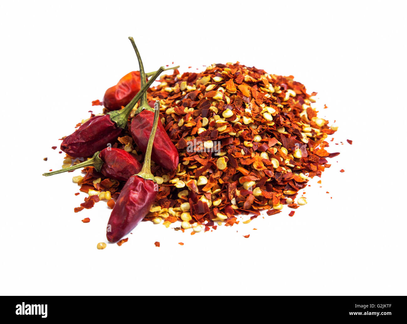 Chili flakes and peppers heap isolated on white Stock Photo - Alamy