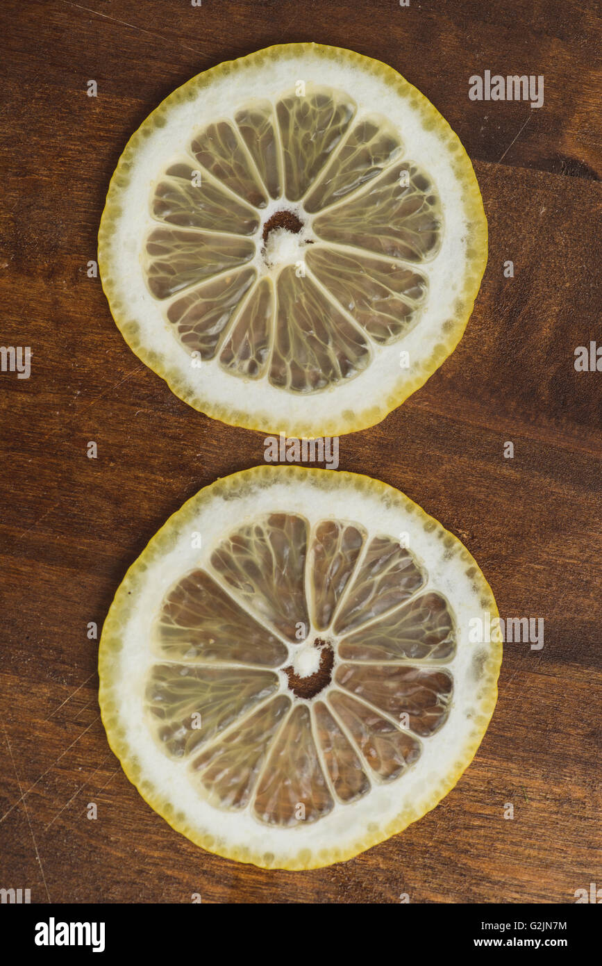 two thin slices Fresh Lemon on Wood Table Background, Rustic Style ...